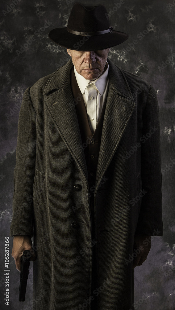 Poster Sinister/Low key image of man in overcoat & hat in sinister pose ...