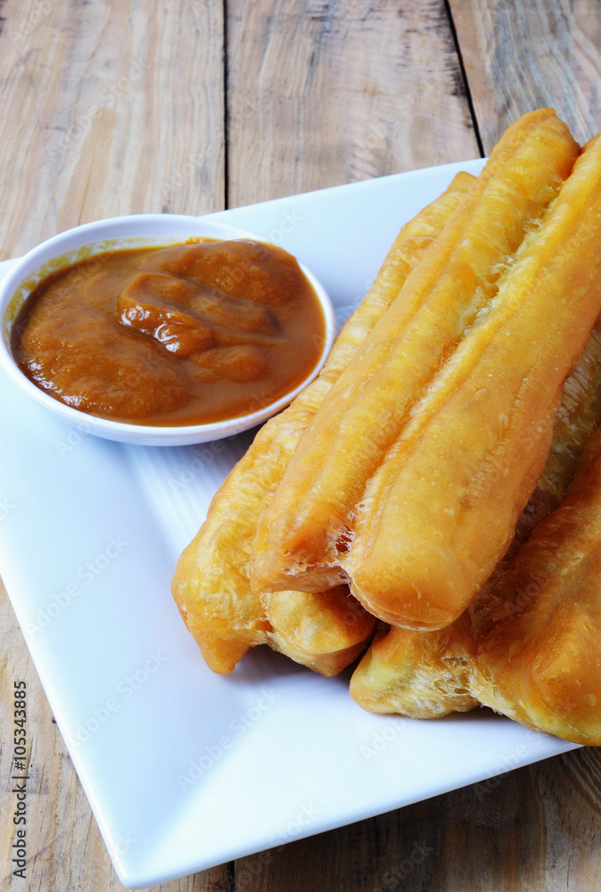 Vertical photo of fried bread stick with coconut jam, the bread is also ...