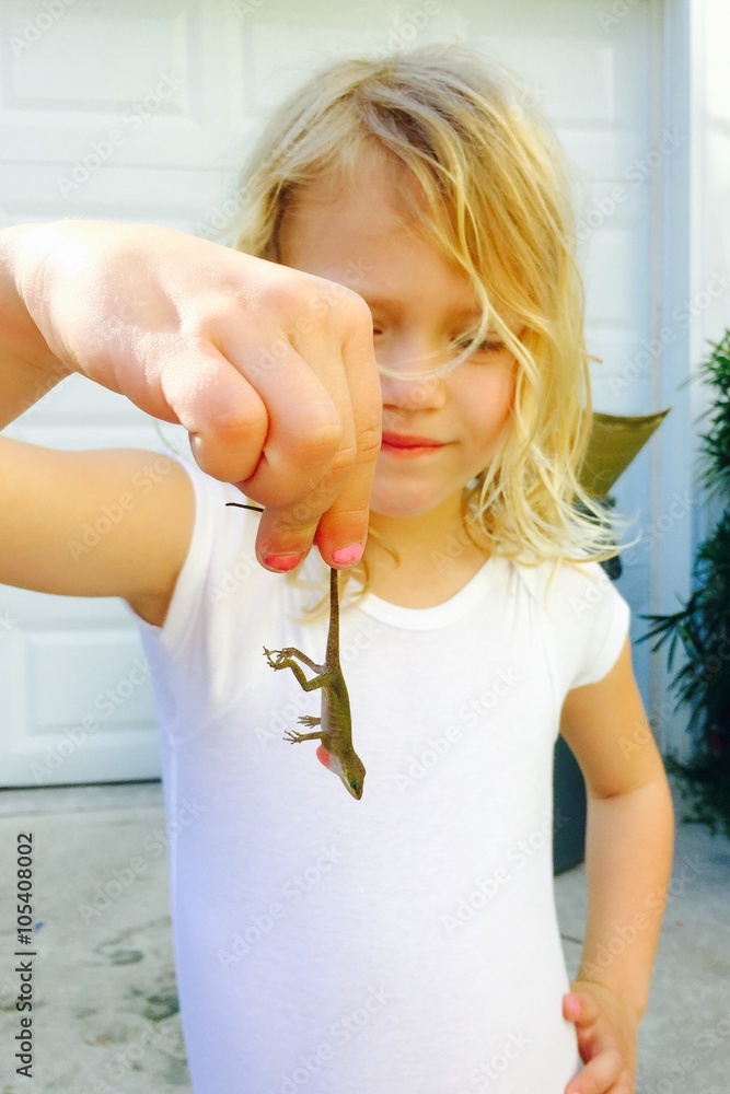 Little Girl Holding a Lizard by its Tail Stock Photo | Adobe Stock