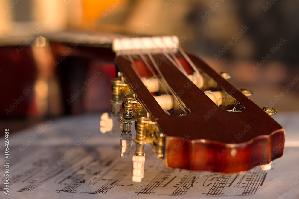 Guitar headstock on music notes, close up Stock Photo | Adobe Stock