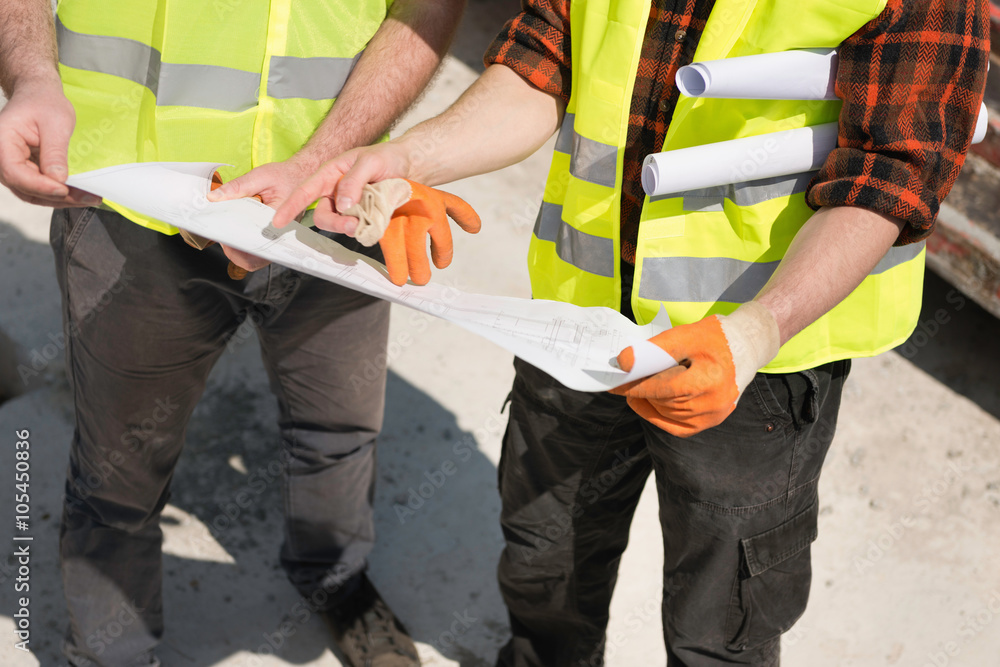 Construction workers looking at blueprints Stock Photo | Adobe Stock