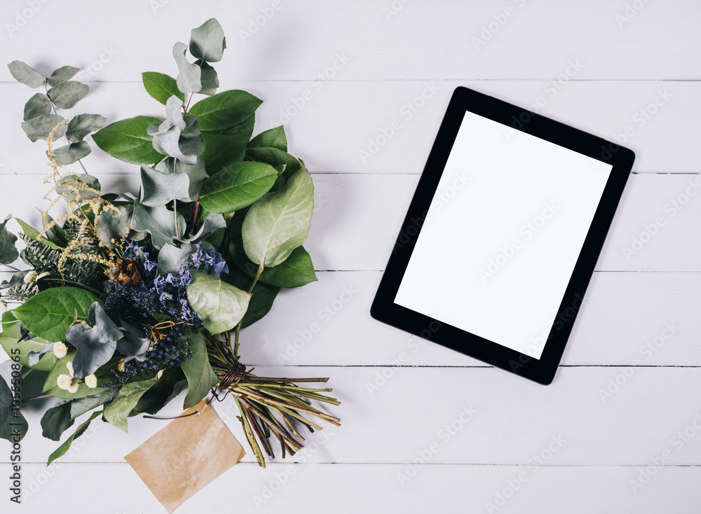 Closeup tablet with a empty blank screen monitor with a bouquet of ...