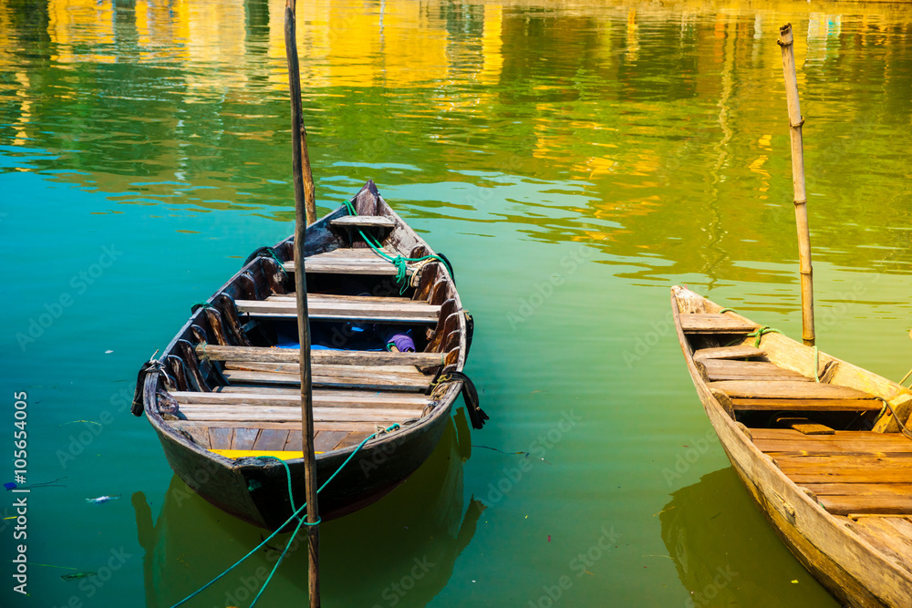 Traditional boats in front of ancient architecture in Hoi An, Vietnam ...