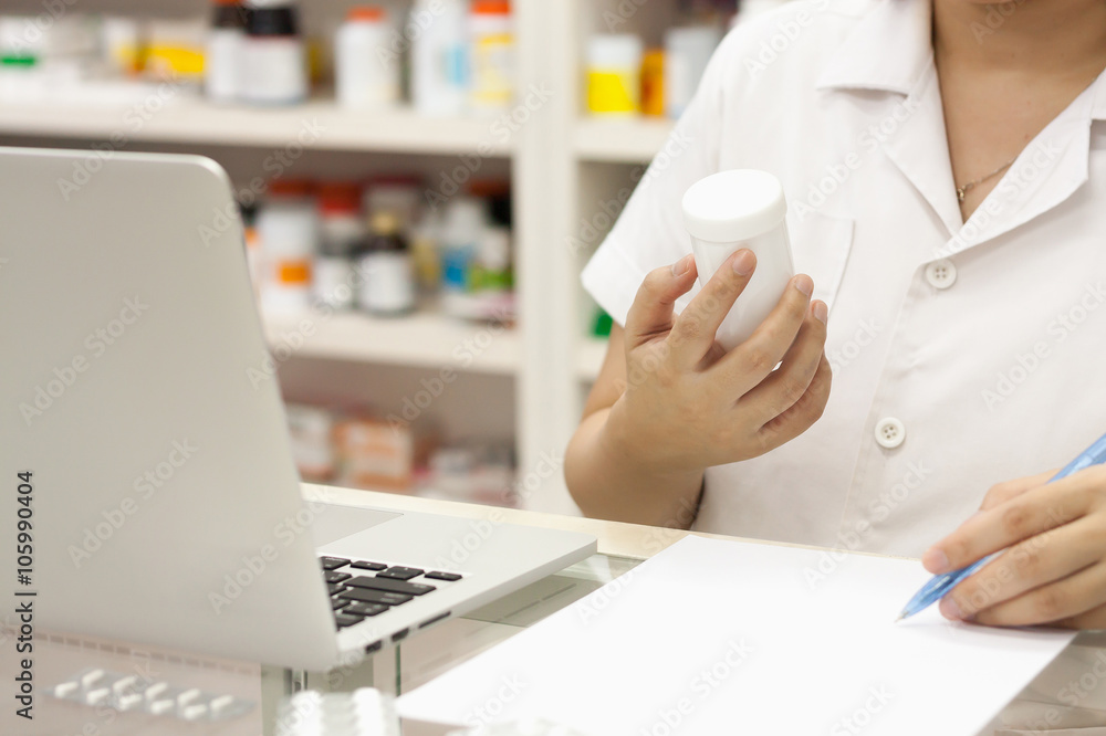 Pharmacist with laptop computer and medication in the pharmacy Stock ...