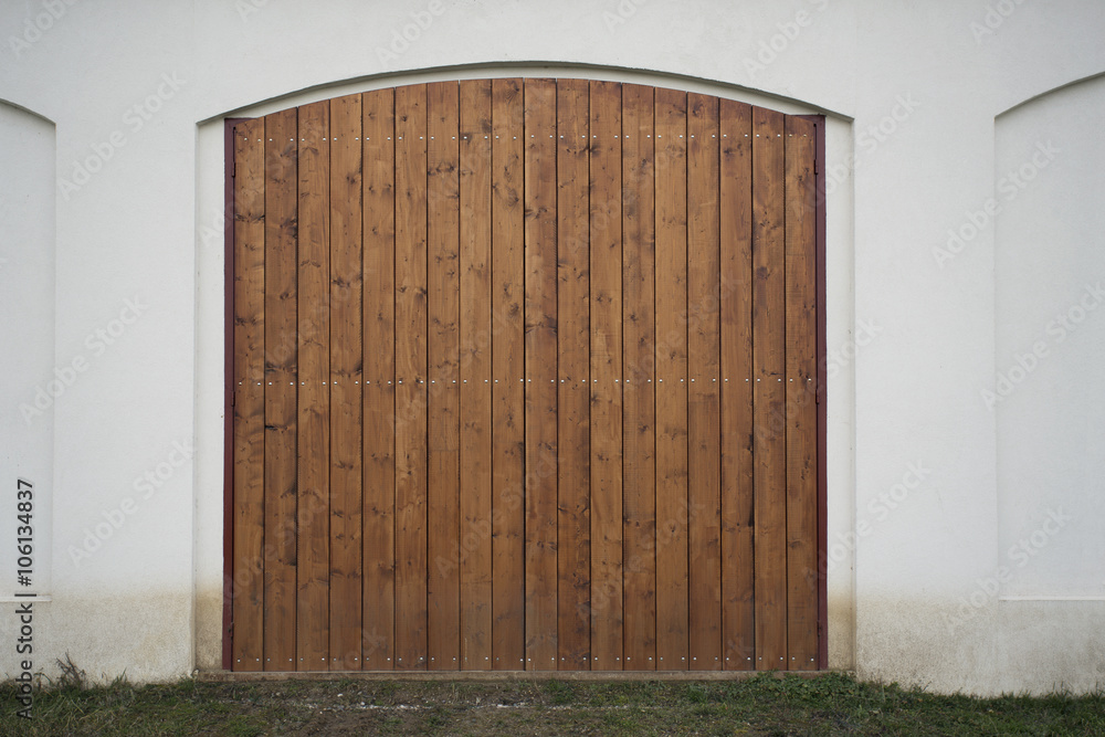 Big wooden barn gate. Monumental farm door, two timber leaf, closed ...