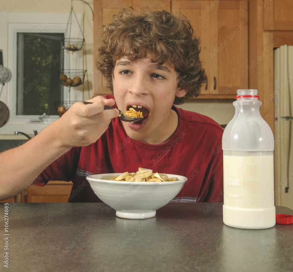 Cute teenage boy enjoying cereal ay breakfast Stock Photo | Adobe Stock