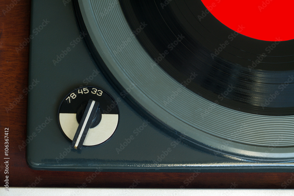Part of vintage record player with wood finish and vinyl record with ...