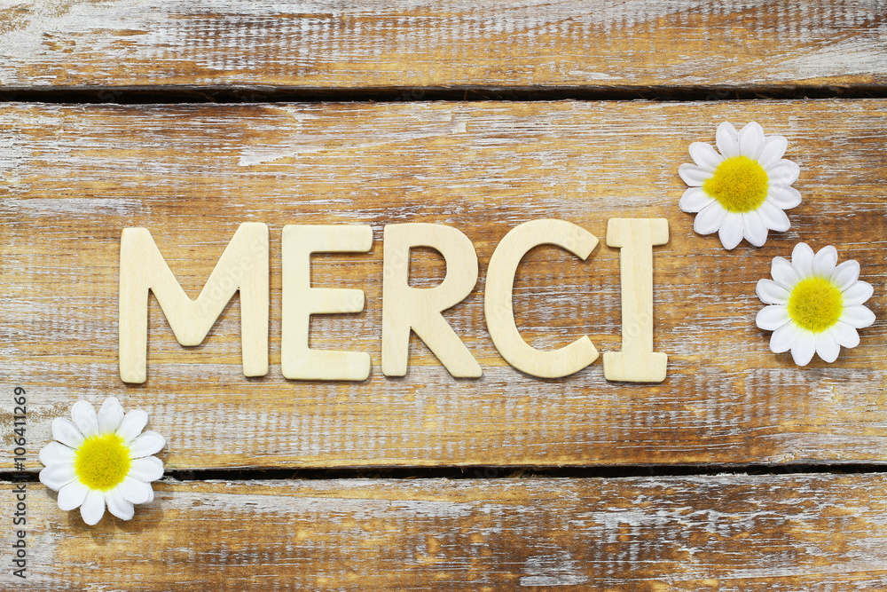 Merci (thank you in French) written with wooden letters on rustic ...