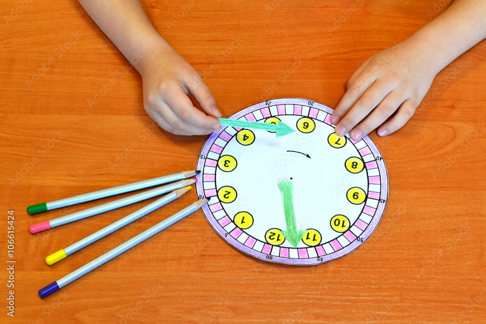 Kid makes paper clock. Children hands, wood table, pencils Stock Photo ...