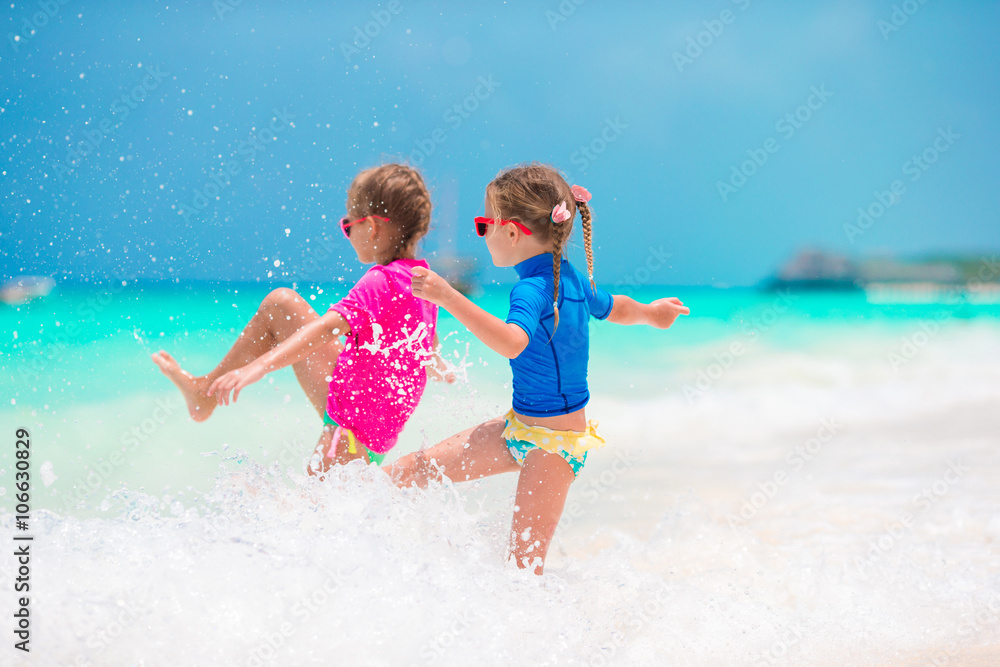 Little girls having fun at tropical beach during summer vacation ...