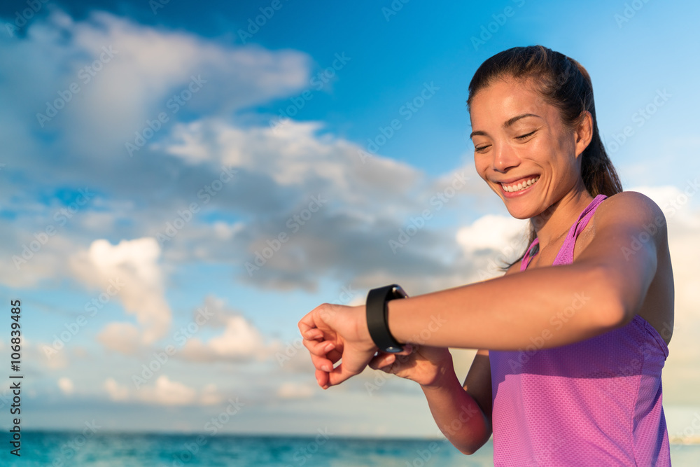 Active girl using fitness tracker smart watch jogging on summer nature ...