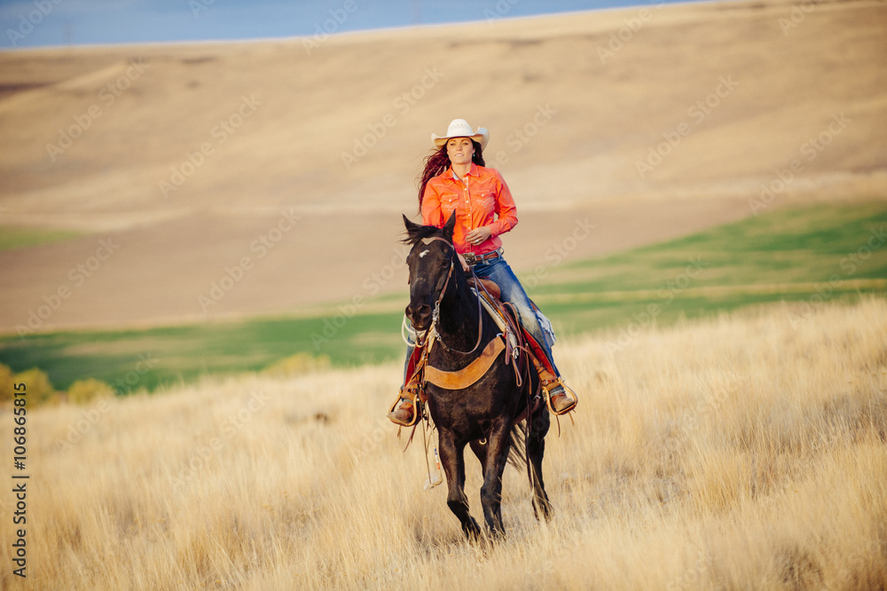 Caucasian woman riding horse in grassy field Stock Photo | Adobe Stock