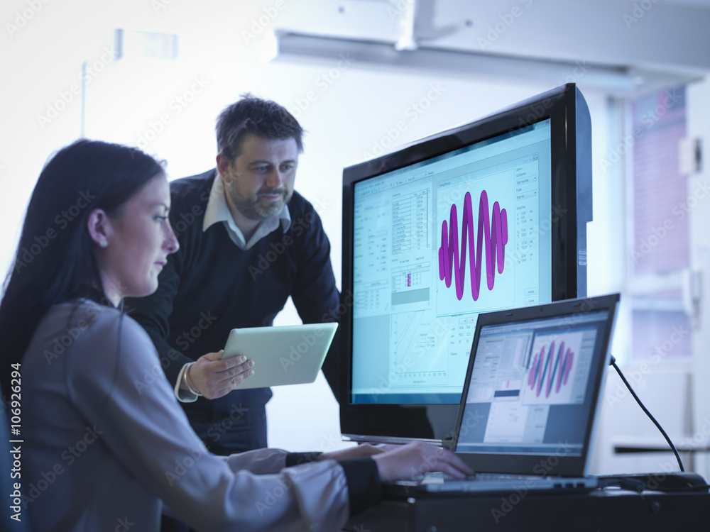 Workers using software to calibrate springs in office Stock Photo ...