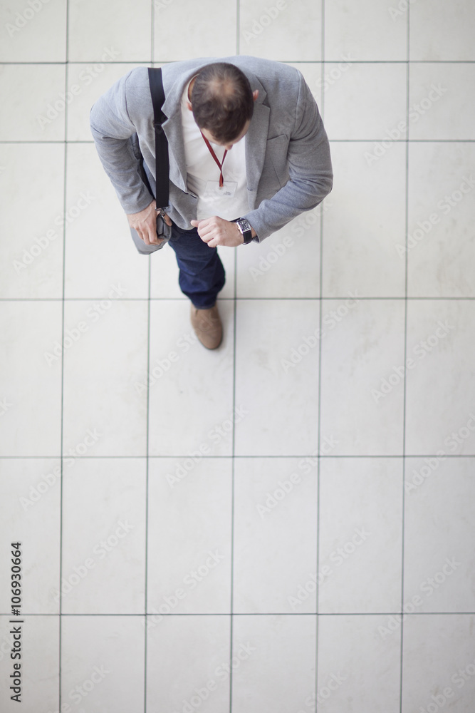 Overhead view of businessman walking through conference centre atrium ...