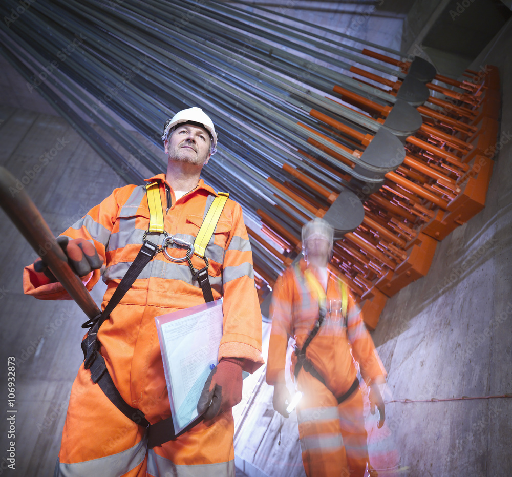 Portrait of engineers in front of cable anchorage in suspension bridge ...