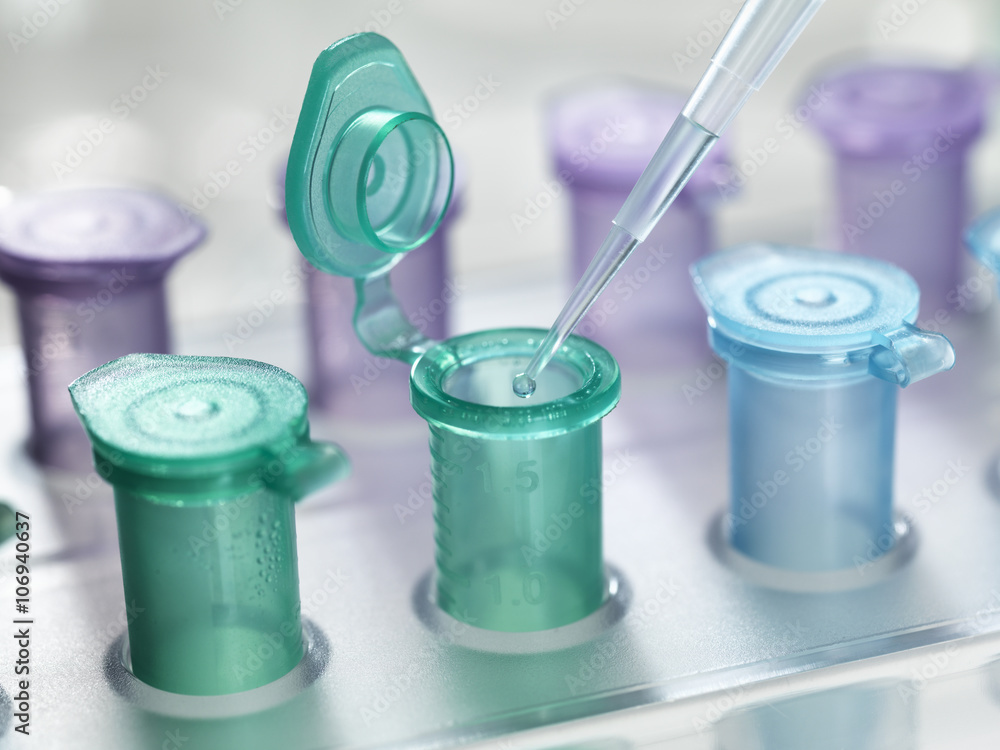 Pipette dropping a solution into a vial, used for storing liquid during ...