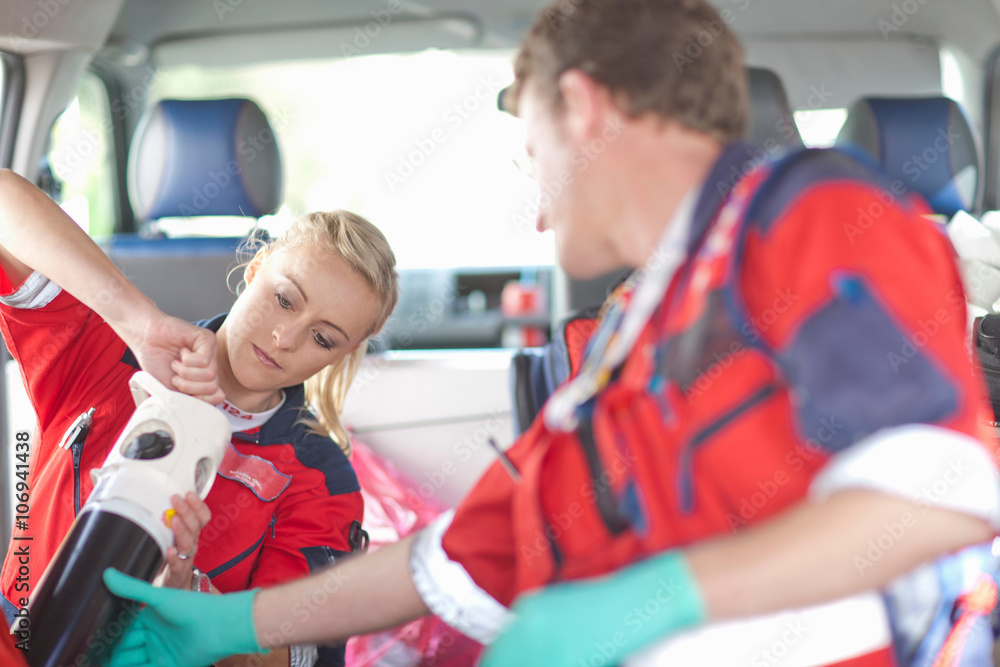 Paramedics in ambulance checking oxygen tank Stock Photo | Adobe Stock