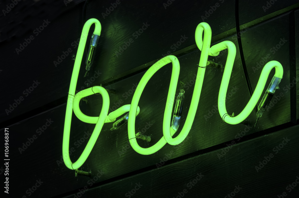 Neon bar sign.Green Neon Sign on black background on the facade of a ...