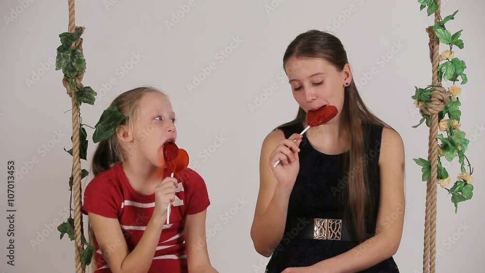 Vidéo Stock Young girls sitting on the swing and enjoy candy.Young ...