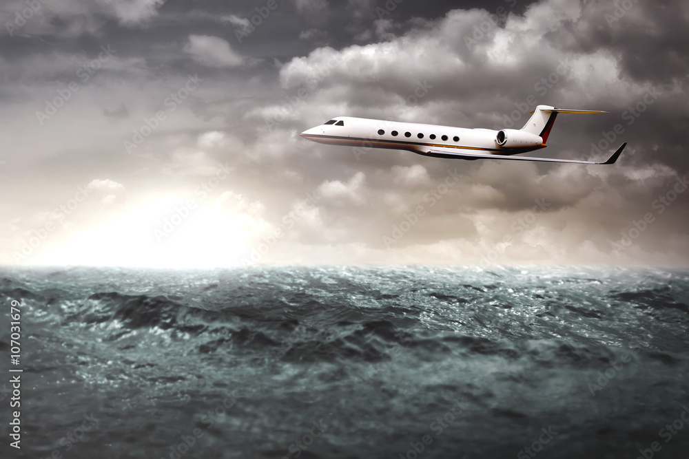 Private jet flying over the ocean Stock Photo | Adobe Stock