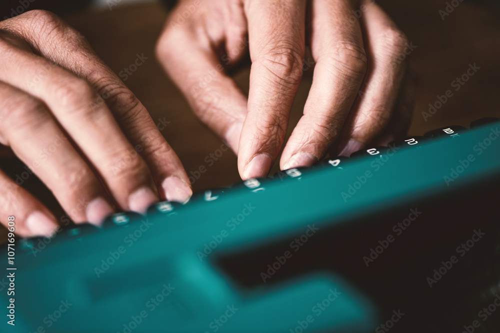 man typing in a retro blue typewriter Stock Photo | Adobe Stock