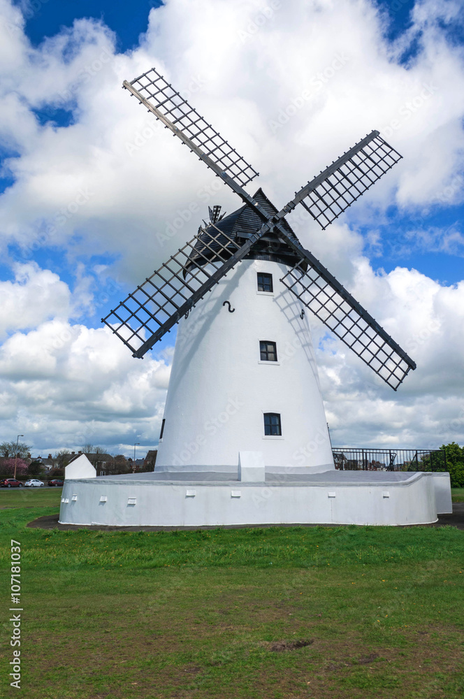 Windmill with black sails ,wooden slatted roof against blue sky with ...
