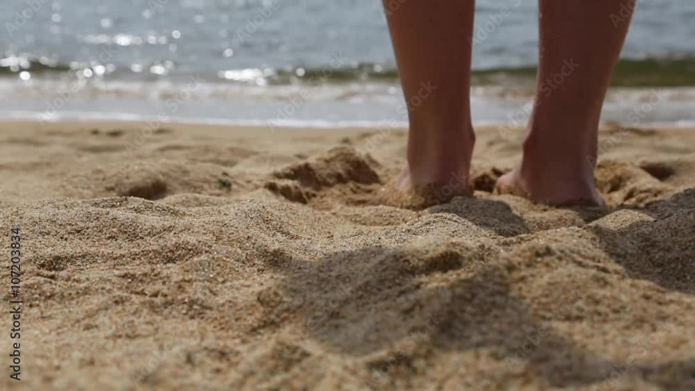 Slender young woman takes off her bikini and goes to swim in the sea ...