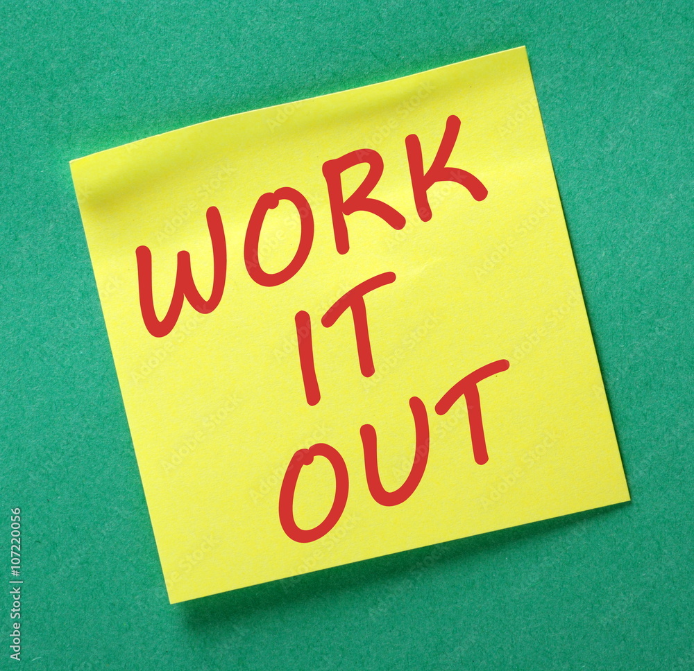 The words Work It Out in red text on a yellow sticky note posted on a ...