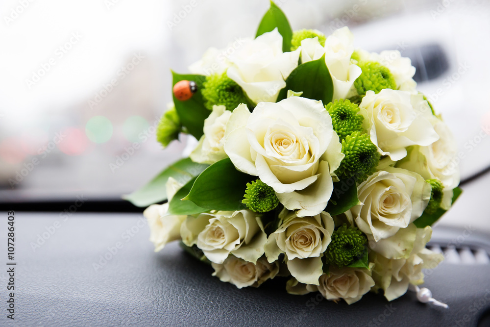 Bridal bouquet of white roses next to car windshield on the dashboard ...