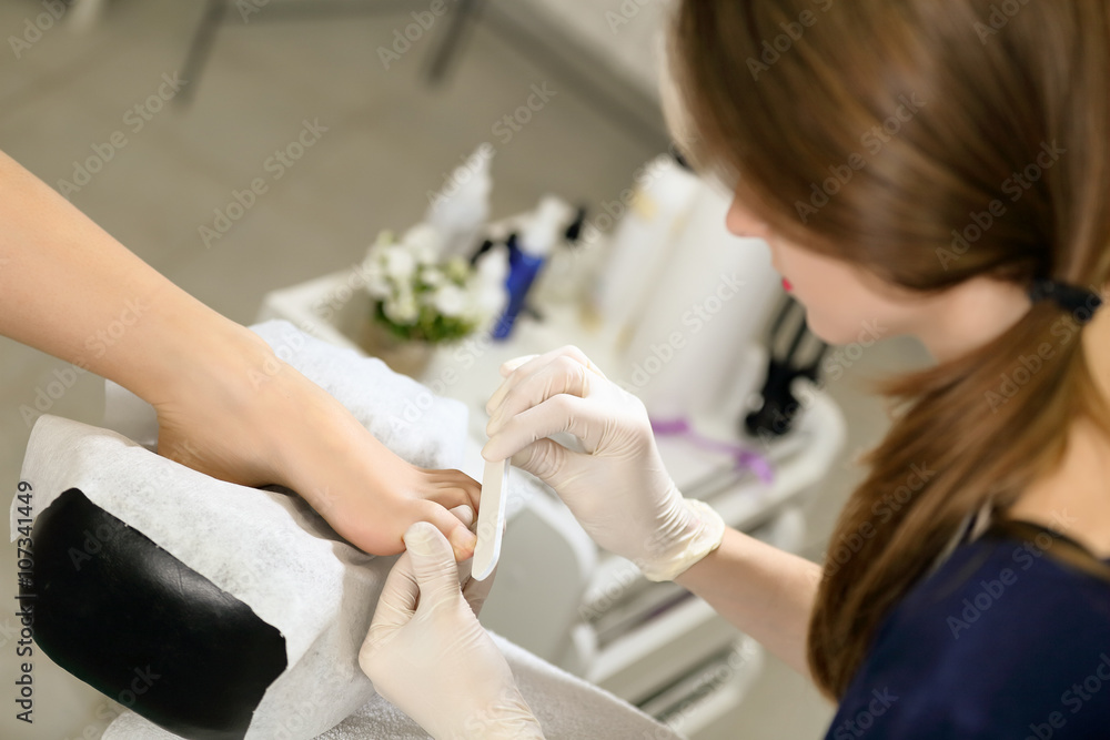 View behind the master during a pedicure in salon. The process of ...