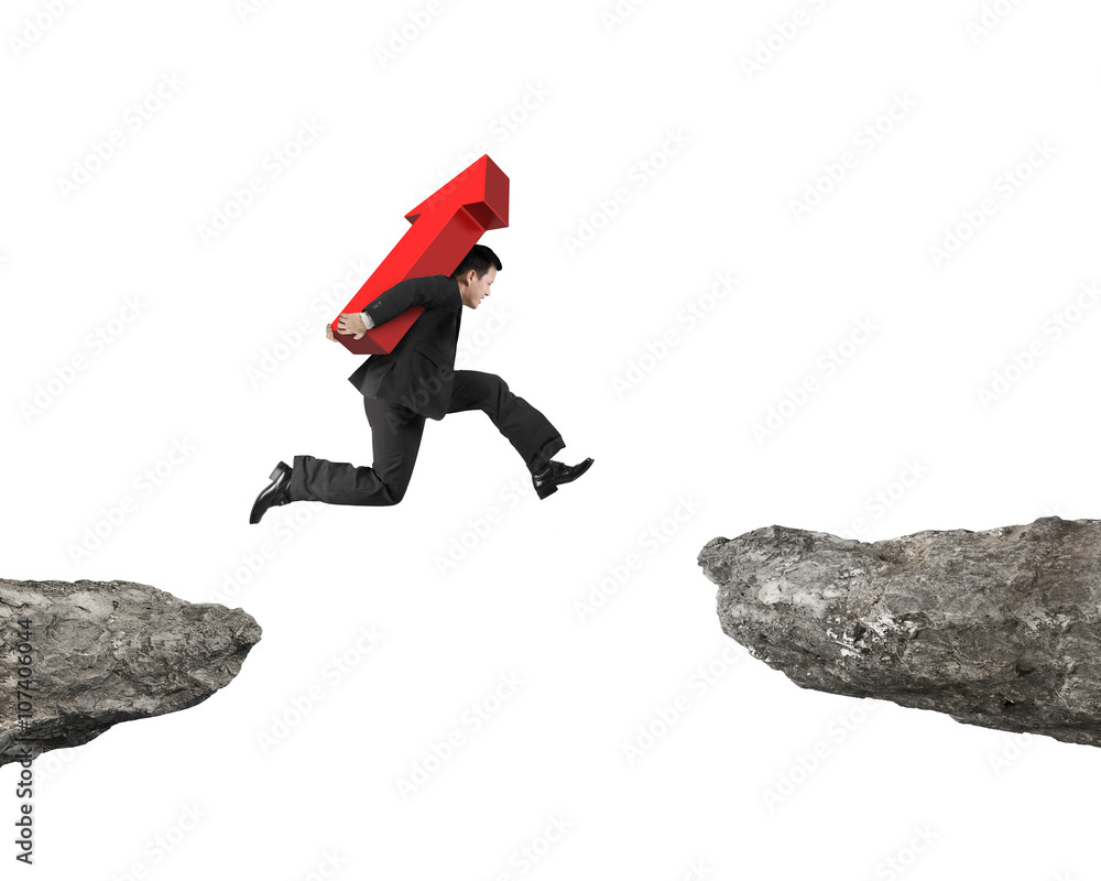 Man carrying red arrow sign jumping over two cliffs Stock Photo | Adobe ...