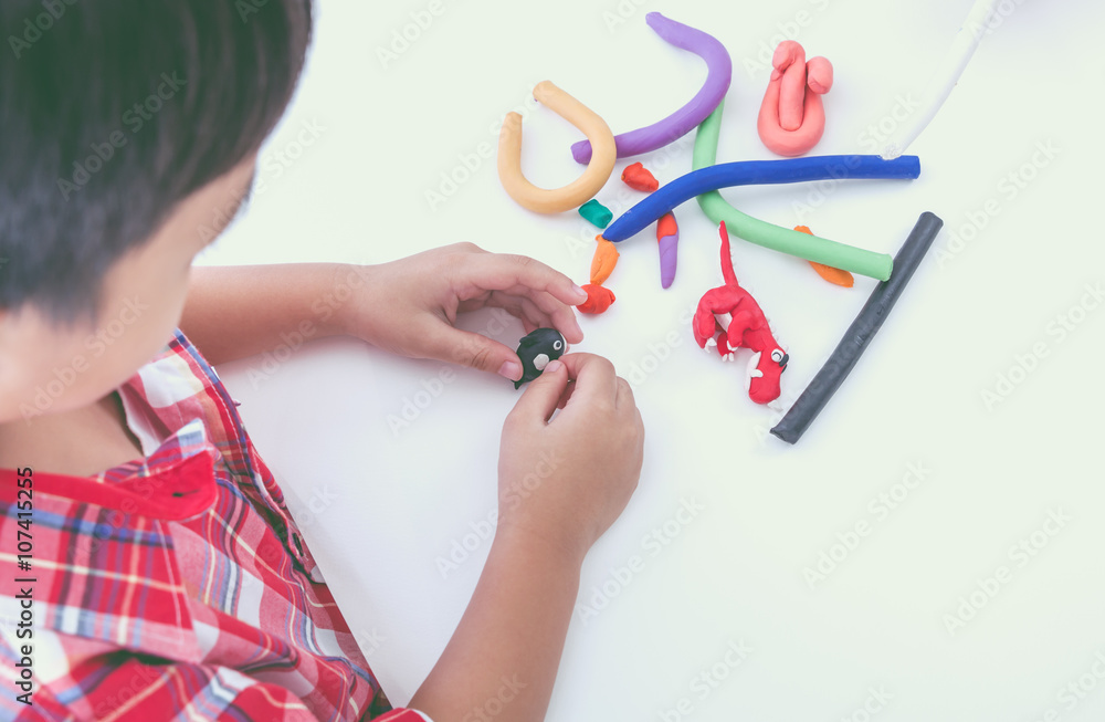 Child molding model clay, on white background. Strengthen the ...