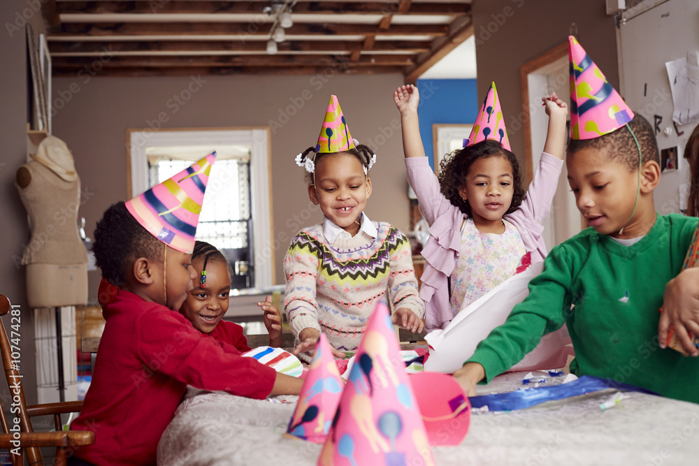 Children wearing party hats and celebrating at table Stock Photo ...