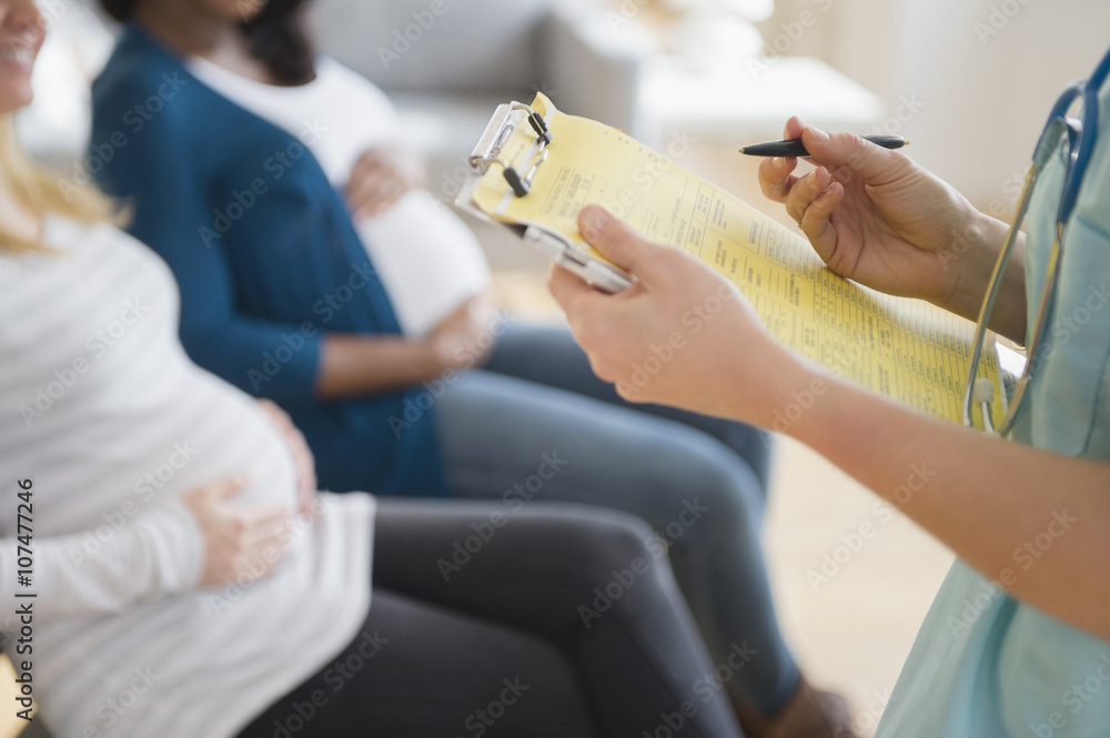 Nurse making medical chart for pregnant woman in hospital Stock Photo ...