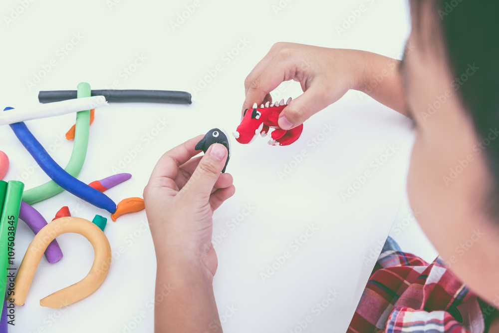 Child molding model clay, on white background. Strengthen the ...
