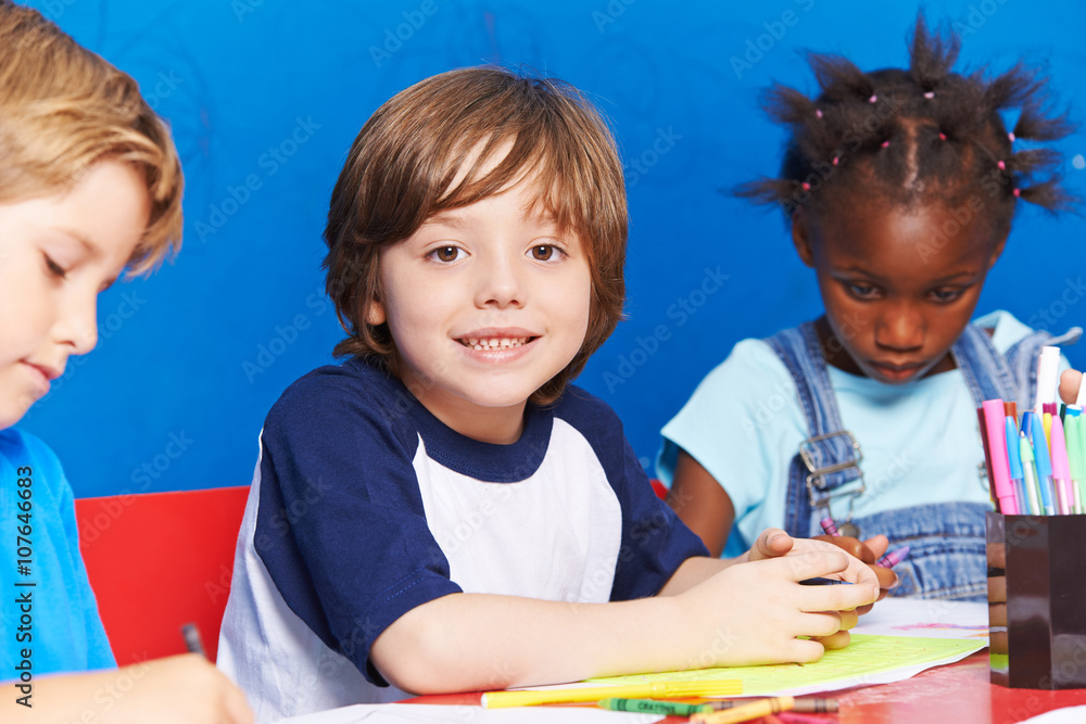 Kind beim Malen am Tisch in der Kita Stock Photo | Adobe Stock