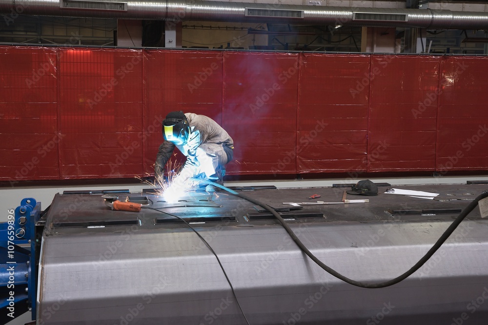 Welder man in work welding a steel sheet by TIG or WIG welding ...