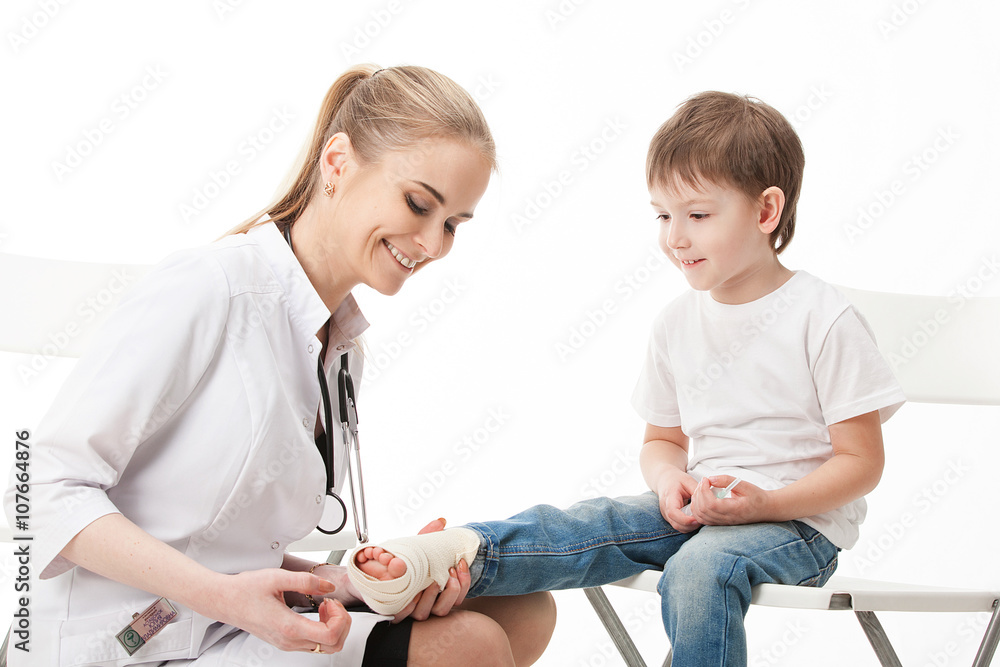 Doctor woman and child patient . Bandaging the leg with a bandage ...