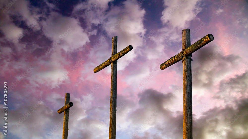 Three old rugged wooden crosses stand tall agaisnt an amazing and ...