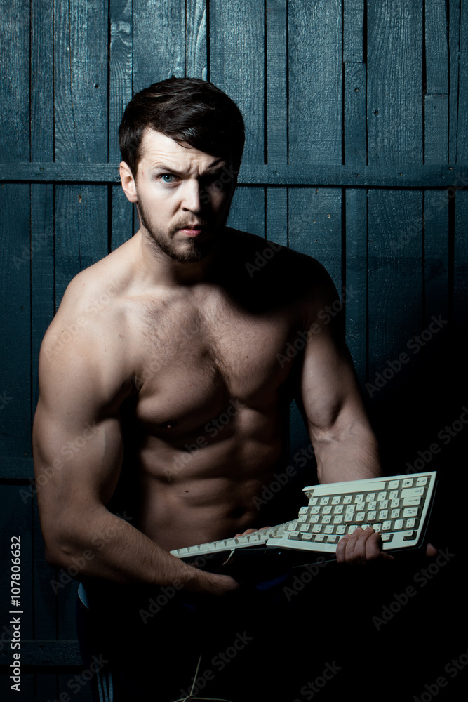 Muscular man with keyboard foto de Stock | Adobe Stock