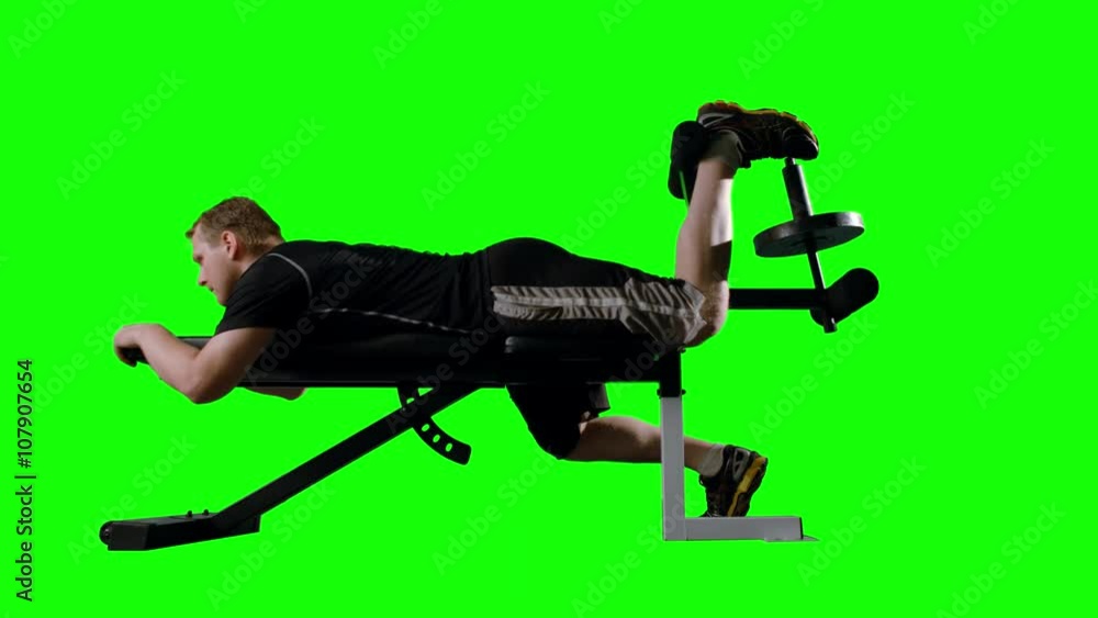 Man working out, doing leg curls on exercise bench. Wide shot in ProRes ...
