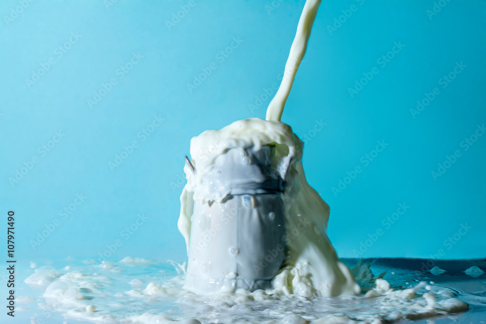 splashes of milk, stream jet of milk pours pouring into a can of milk ...