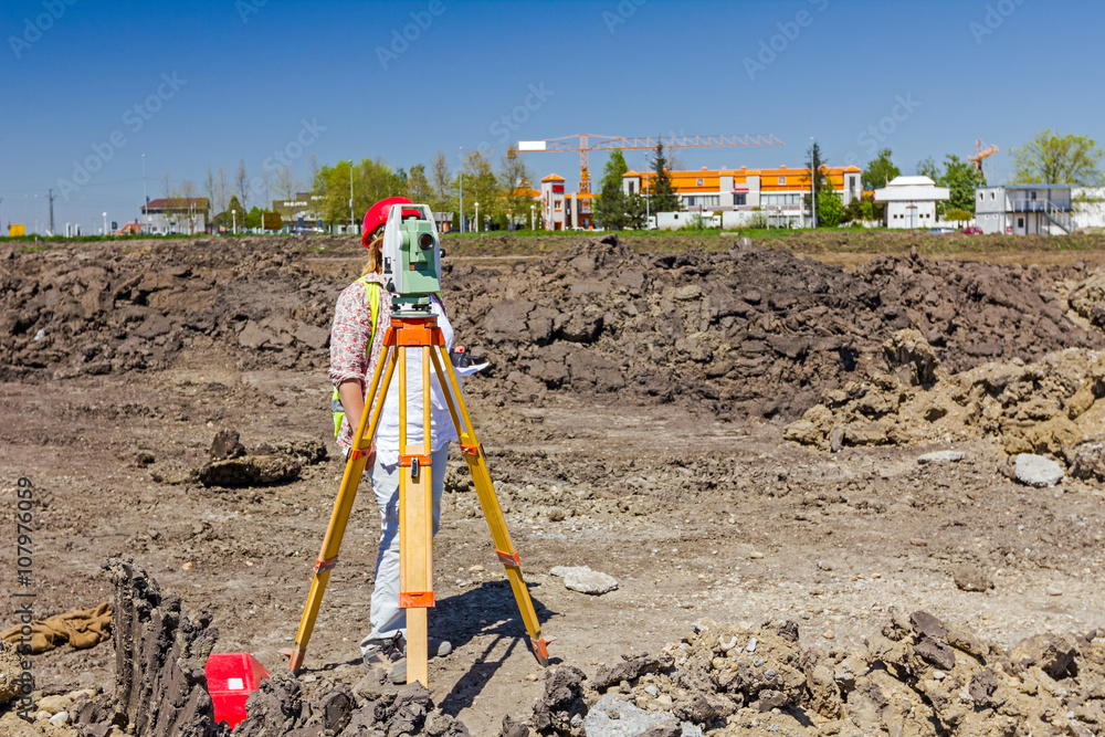 Female geodesist is working with total station on a building sit Stock ...