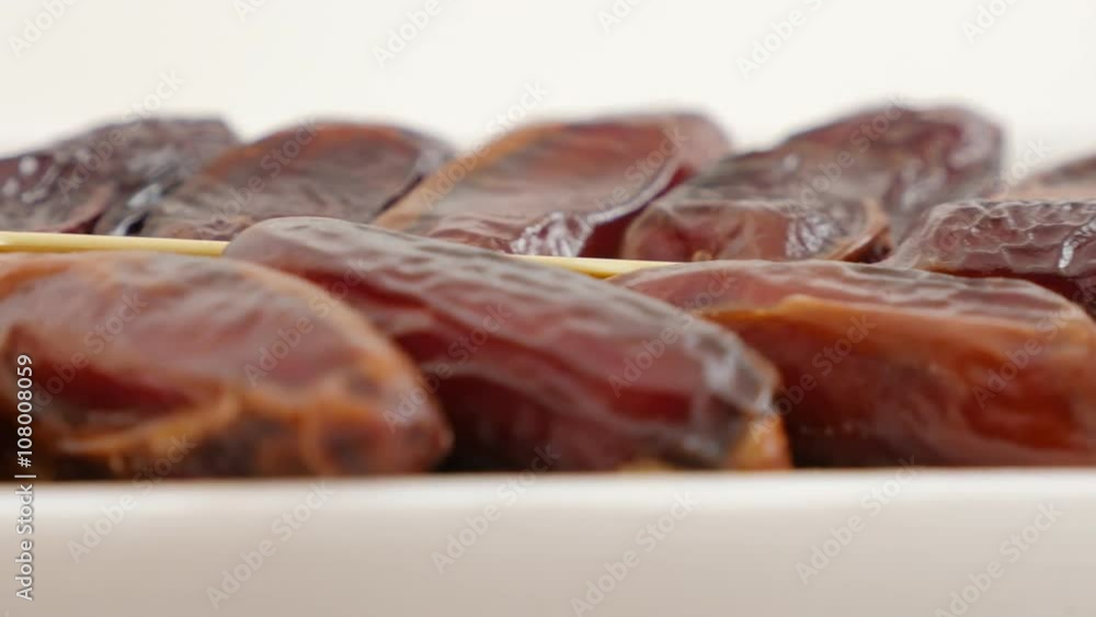Packed palm dates dried fruit on white surface panning 4K 2160p 30fps ...