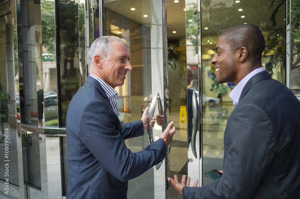 Businessman opening office door for colleague Stock Photo | Adobe Stock