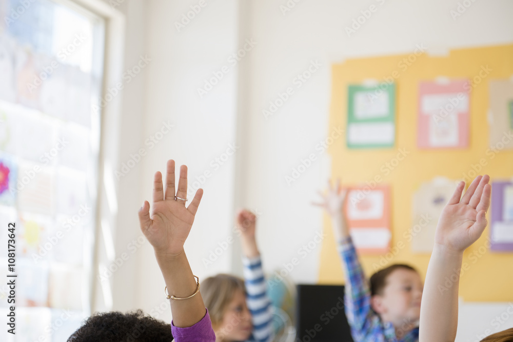 Students raising hands in classroom Stock Photo | Adobe Stock