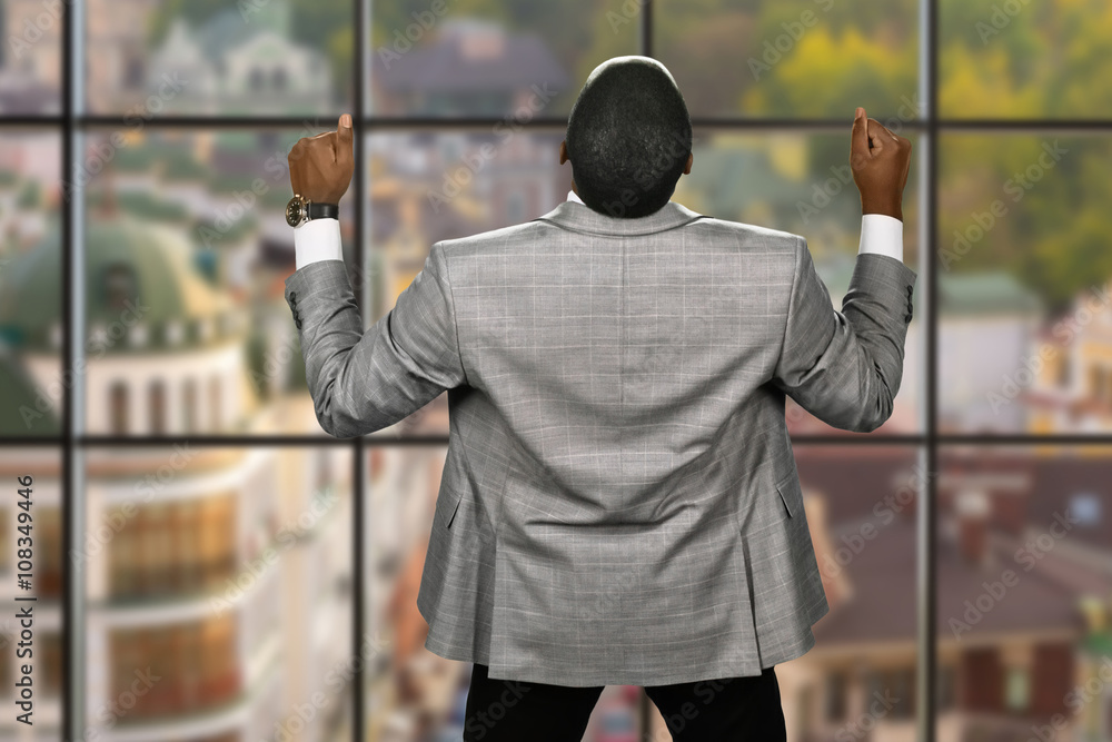 Joyful afro businessman wearing jacket. Back view of elated manager ...