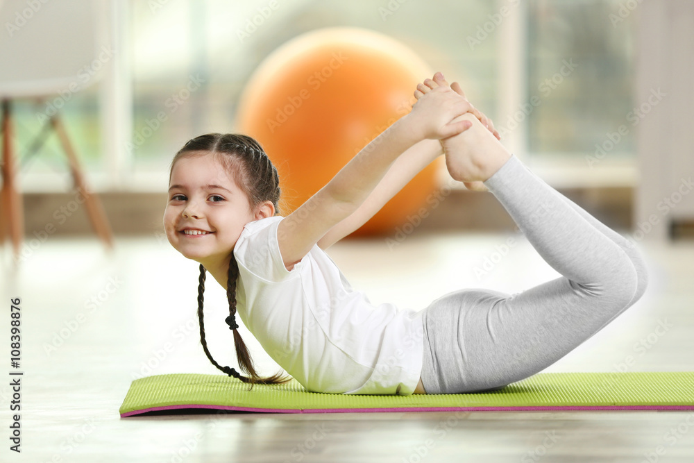 Little cute girl practicing yoga pose on a mat indoor Stock Photo ...