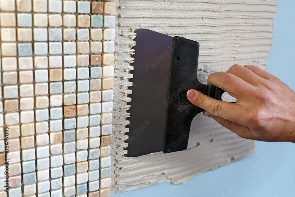 Repair in the apartment: installing the mosaic tile on the wall. Stock ...