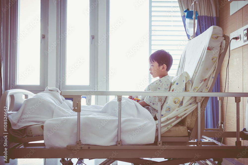 Asian child admitted at hospital room with infusion pump intravenous ...